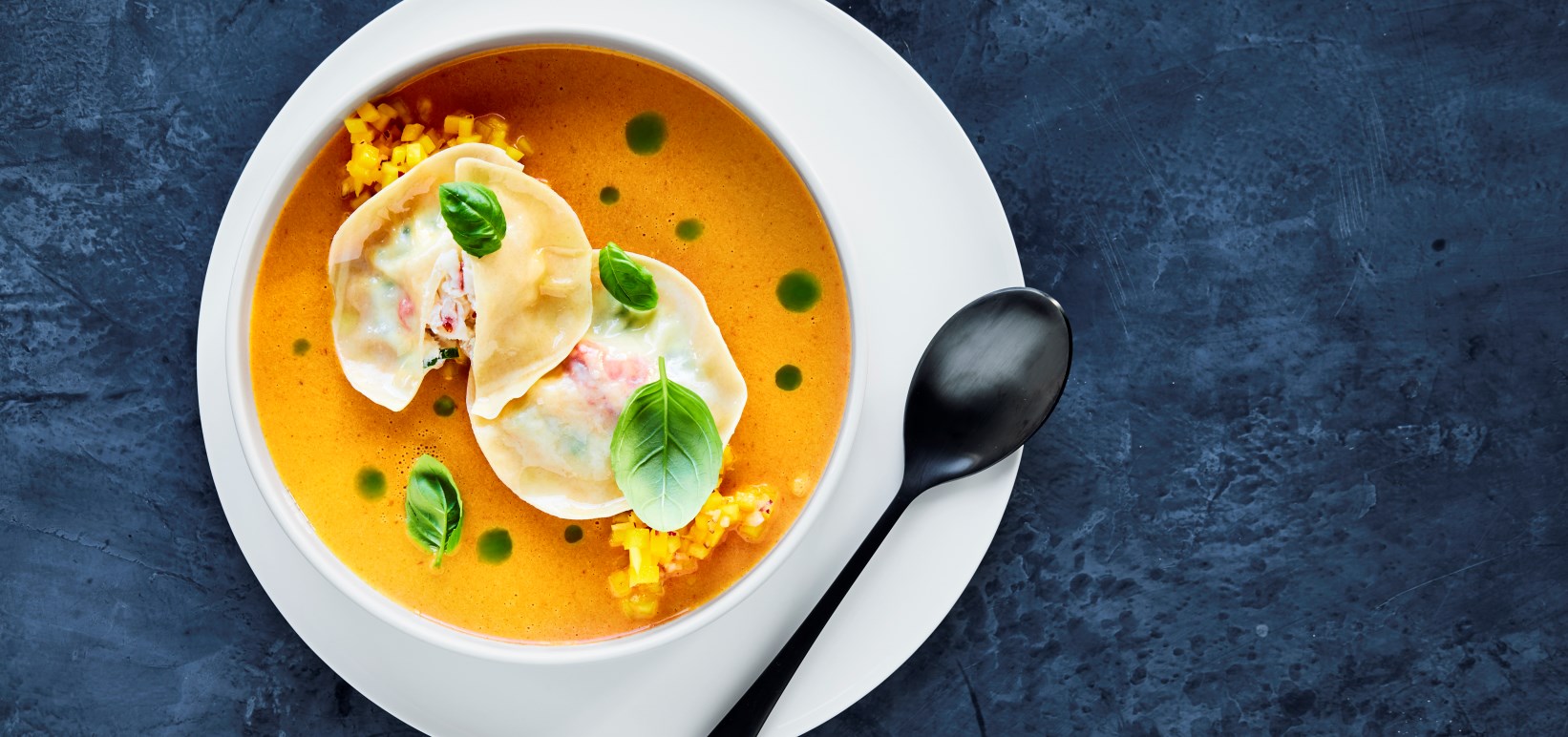 Lobster ravioli in a strong lobster bisque with mango salad and chive ...